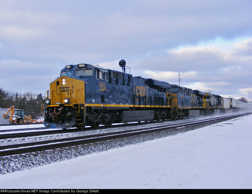 A brand new CSX 965 leads a train west.